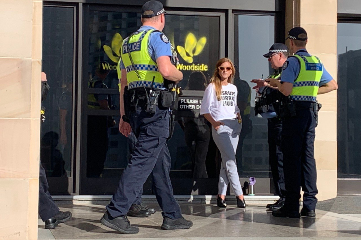 'It's undeniable': Protesters deface Parliament House with Woodside logo